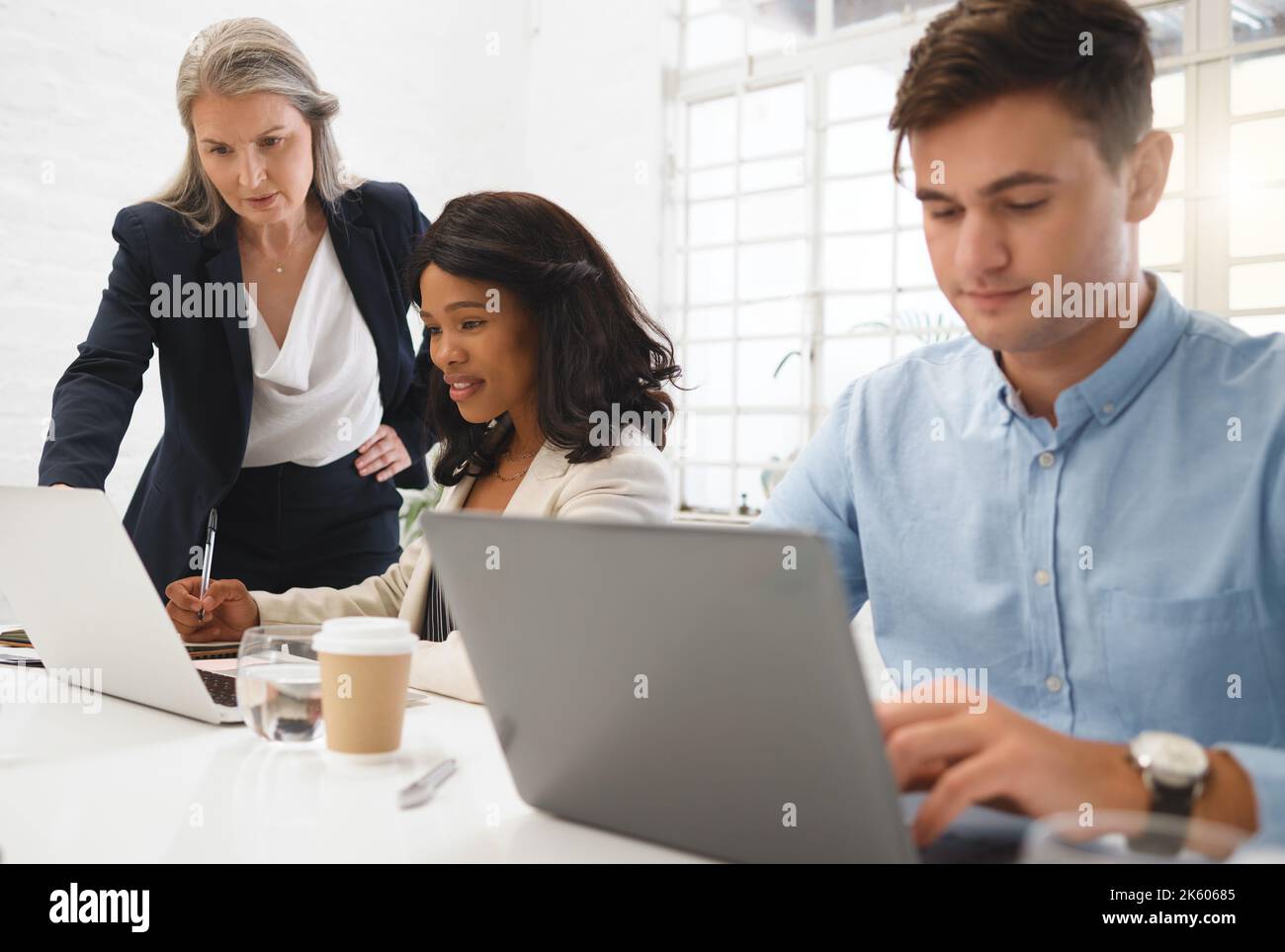 Three diverse businesspeople working together In an office at work ...