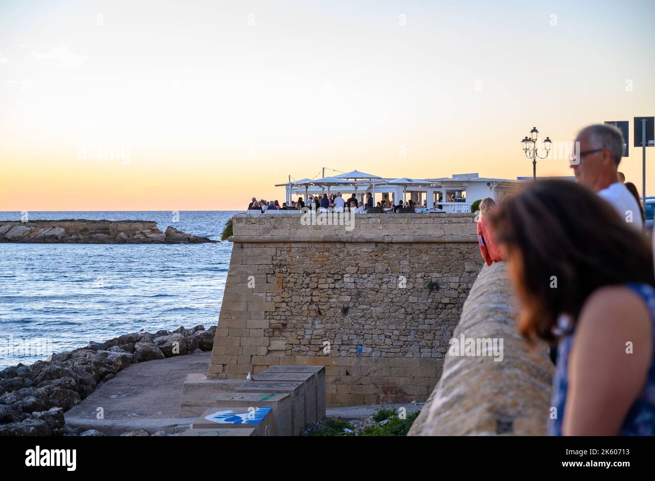 People watching the sun set from the ramparts of the old city wall with ...
