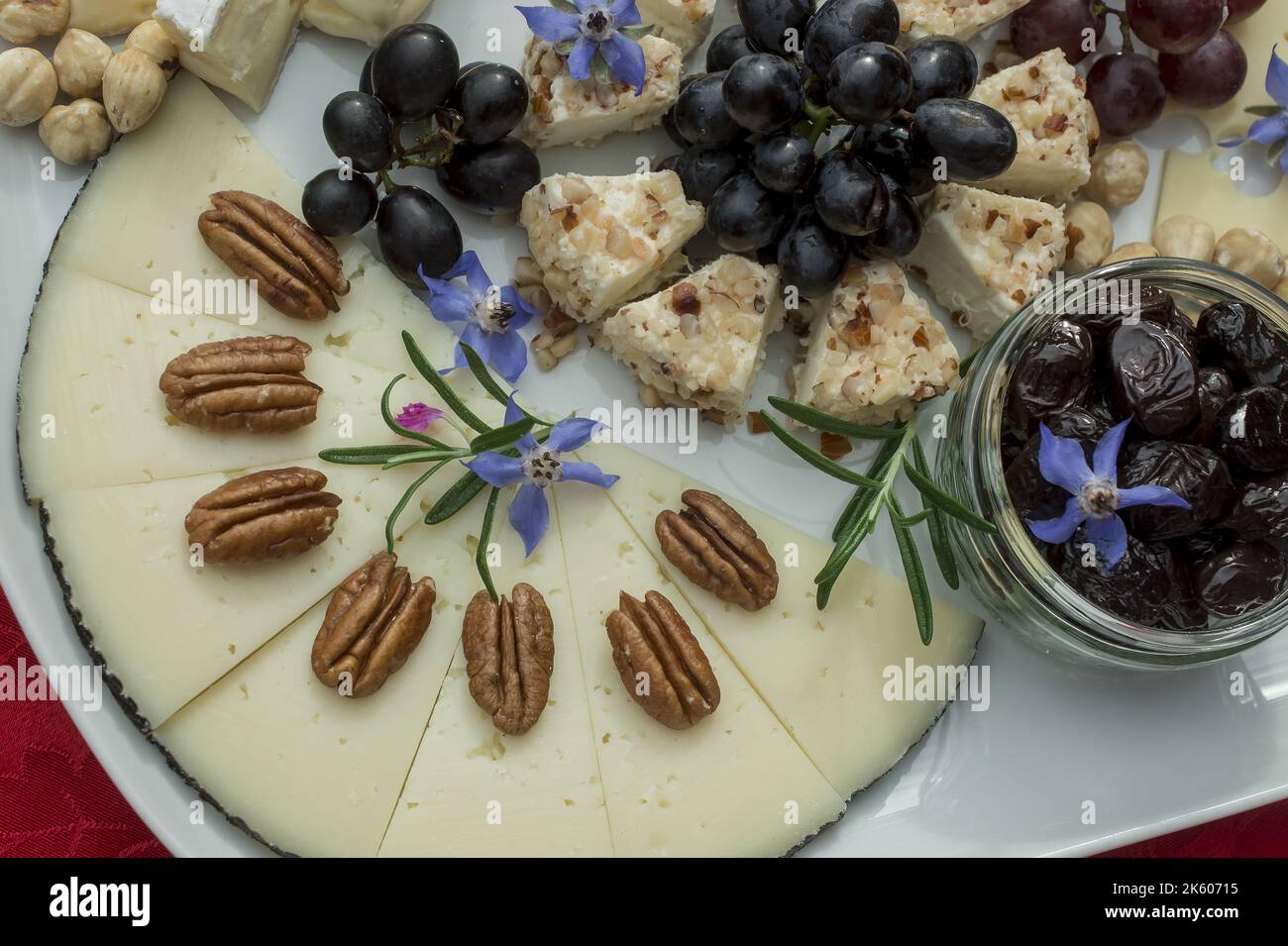 selection of cheeses with grapes and edible flowers Stock Photo - Alamy