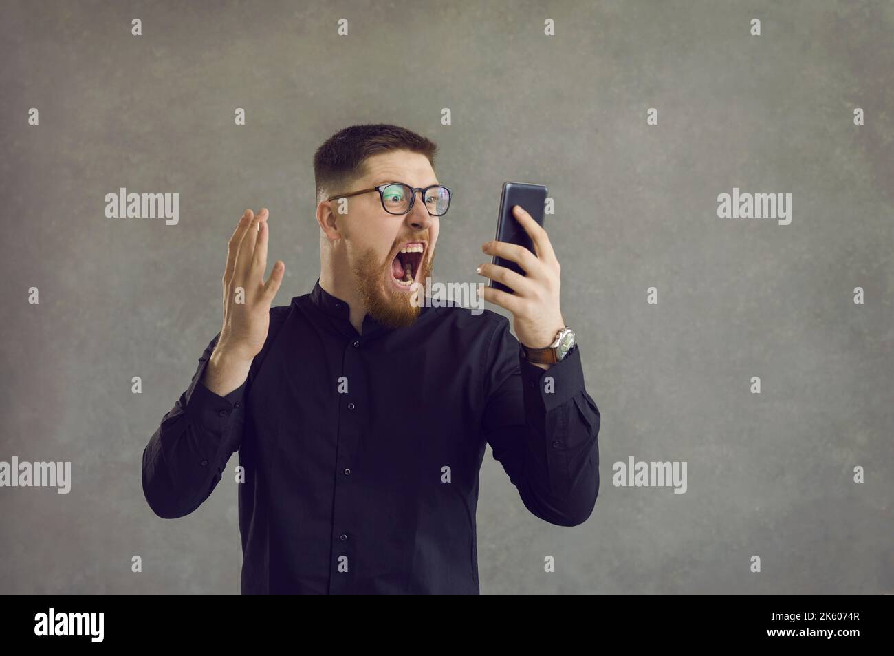 Angry enraged man nervously screams looking with hatred at the screen ...