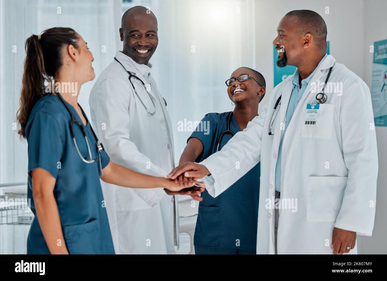 Group of happy diverse doctors stacking their hands together in support ...