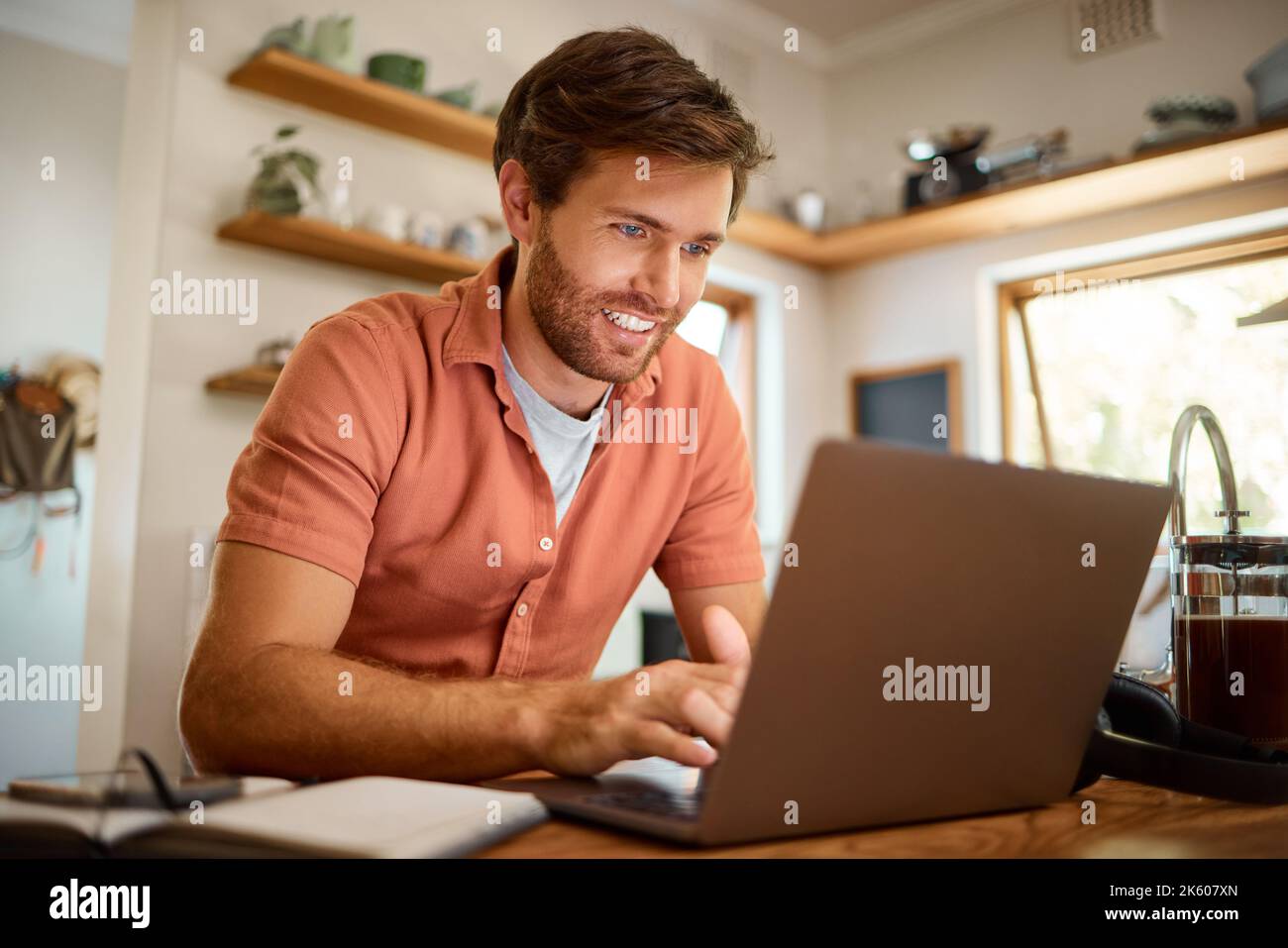Cheerful caucasian businessman working on a laptop at home alone. Happy ...