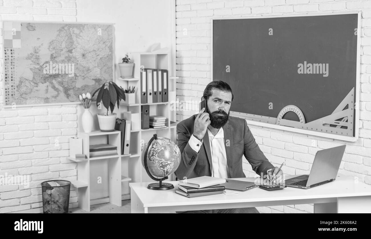 Handsome lecturer or teacher with a confident look with phone at ...