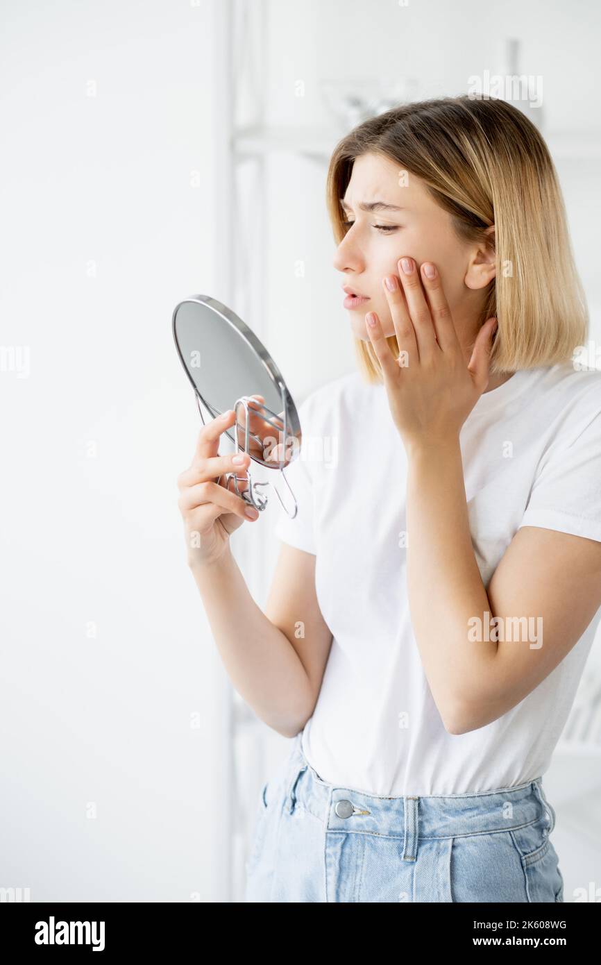 skin problem acne treatment woman touching face Stock Photo - Alamy