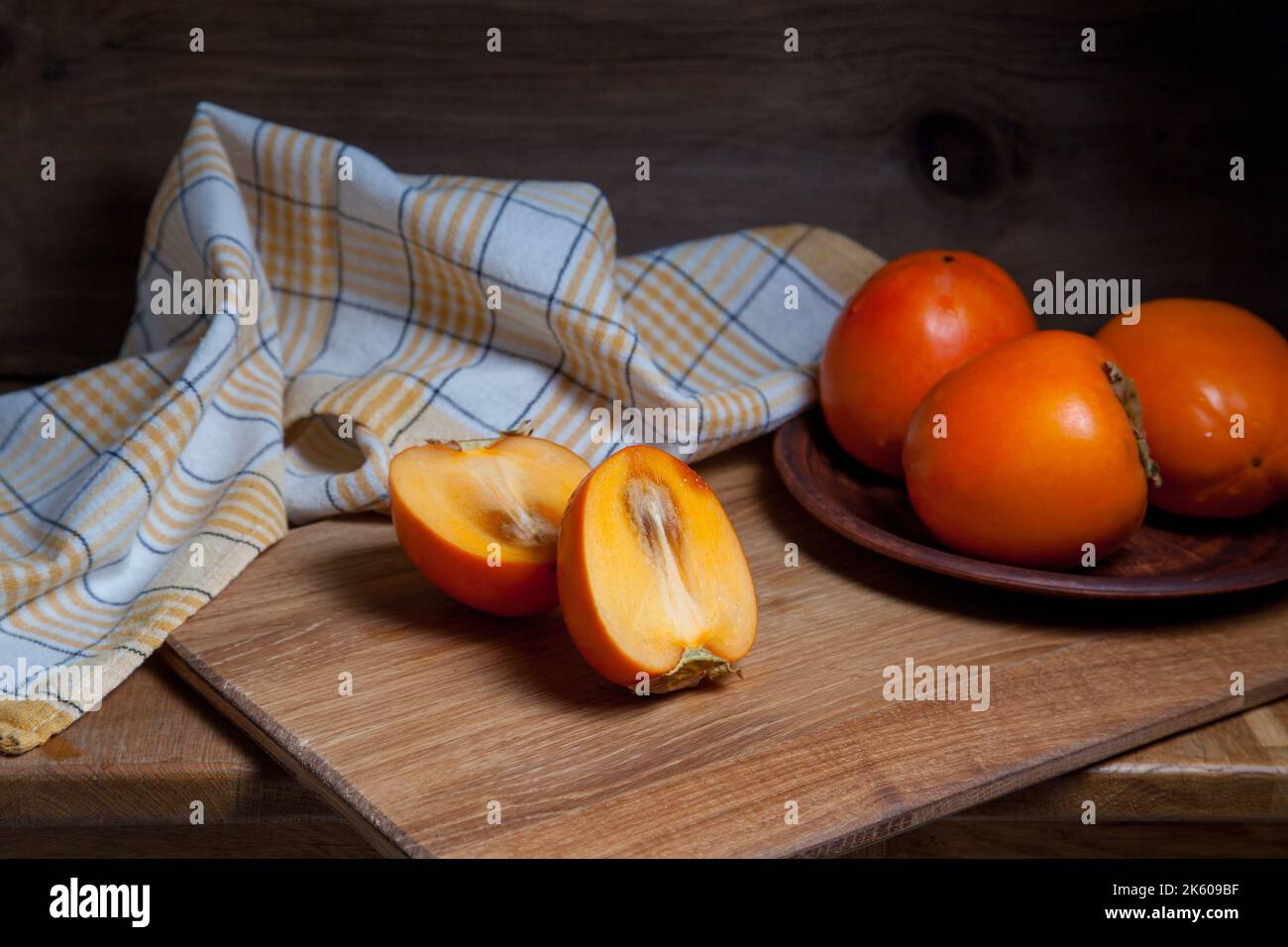 Composition of ripe delicious whole persimmon fruits, half and sliced ...