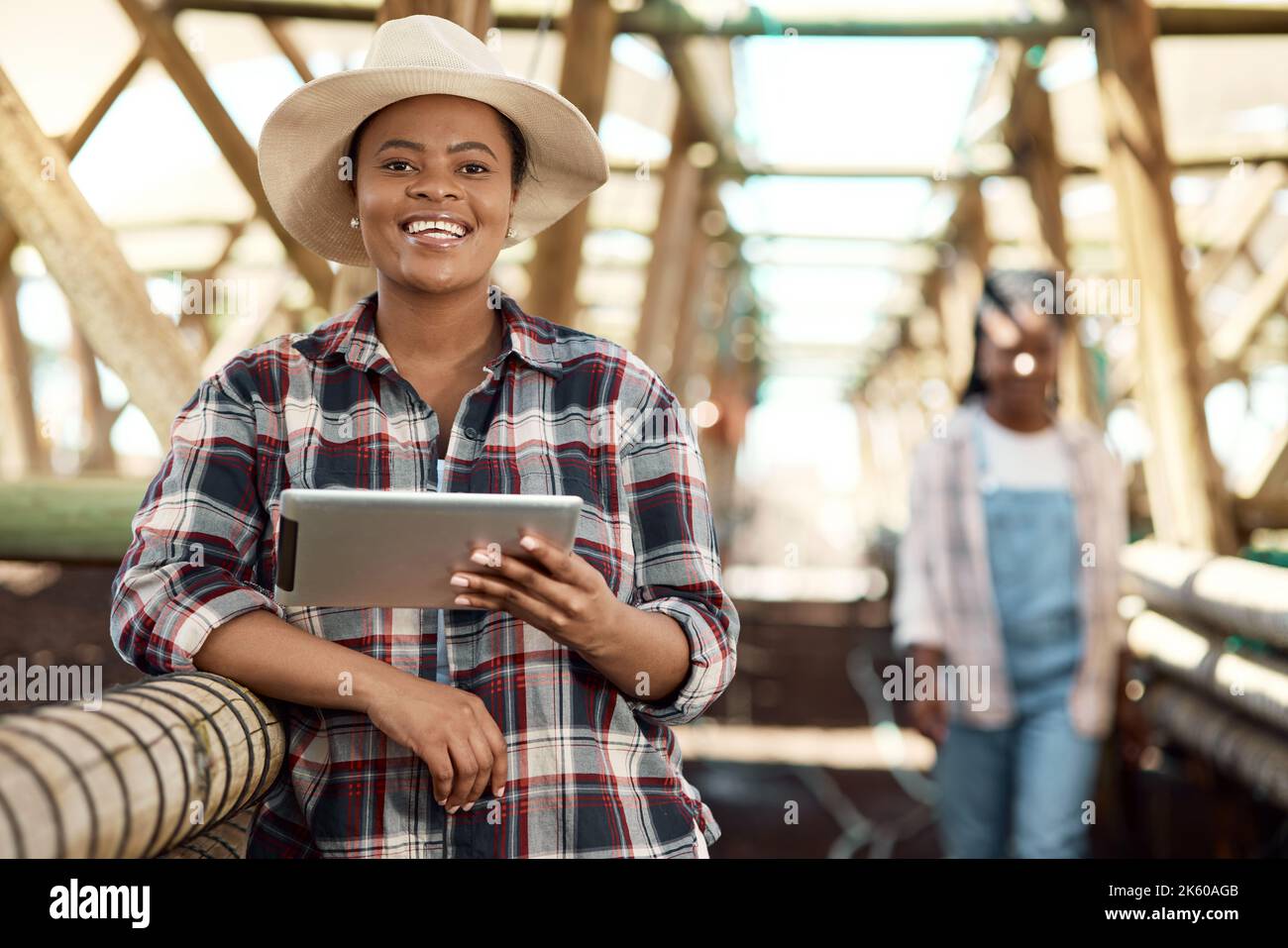 Happy farmer using a digital tablet. African american farmer using a ...