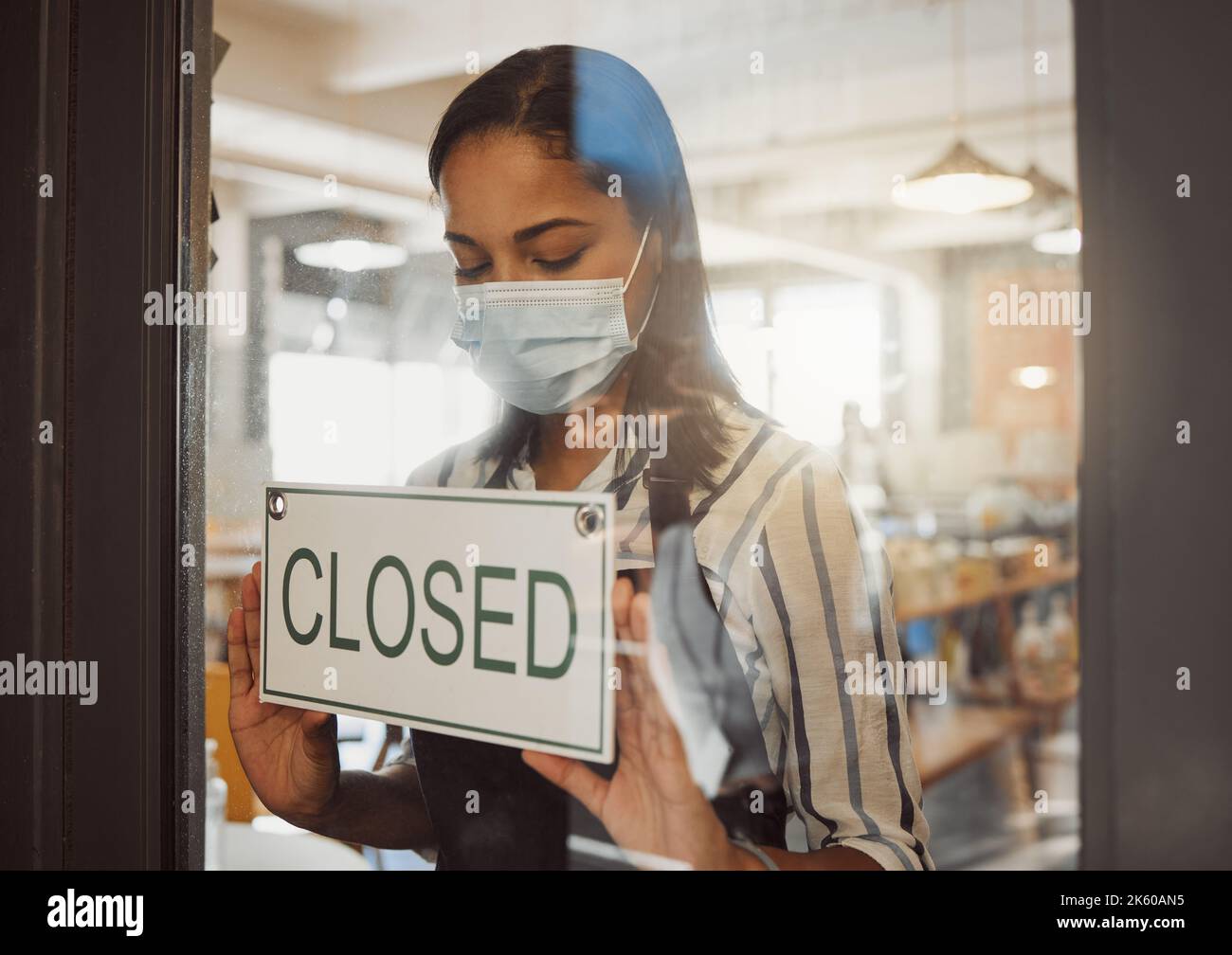 Businesswoman closing her shop in the pandemic. Business owner hanging ...