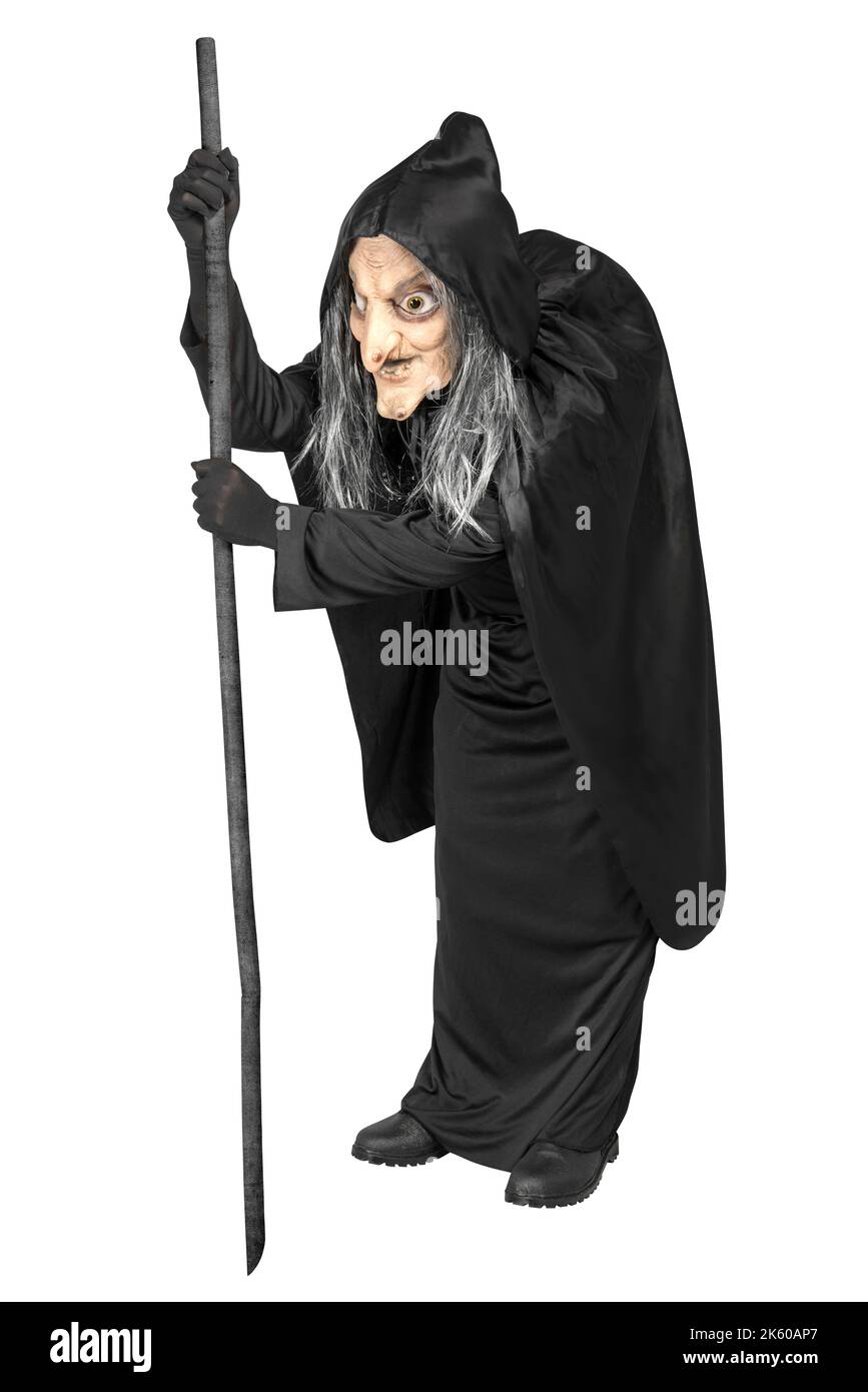 Old witch in a cloak standing with a stick isolated over white ...