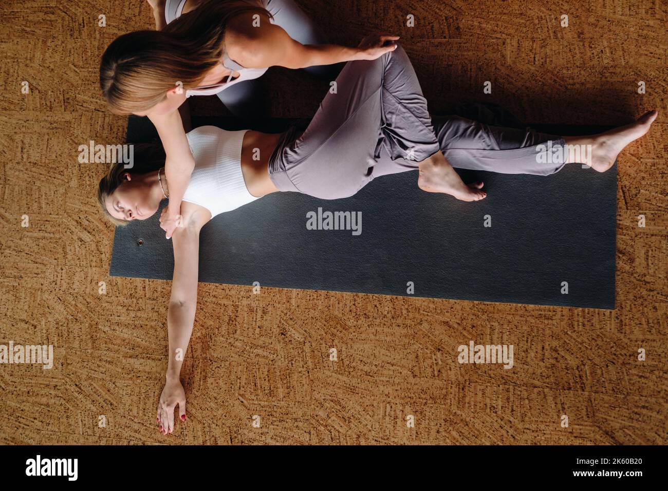 Yoga exercises. A personal trainer teaches a woman yoga classes in the ...