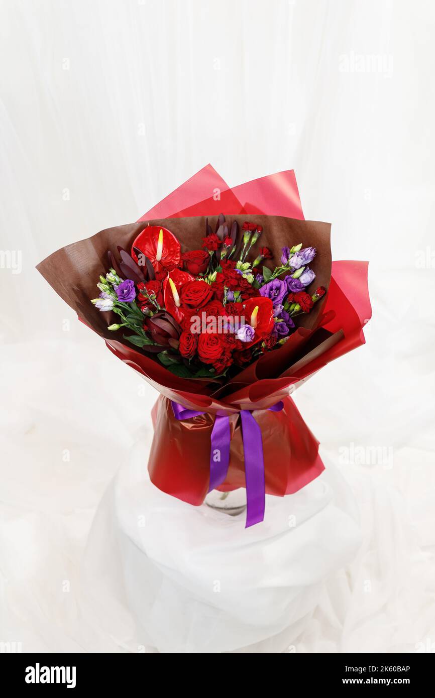 Beautiful large bouquet composed of red and purple flowers on stand on ...