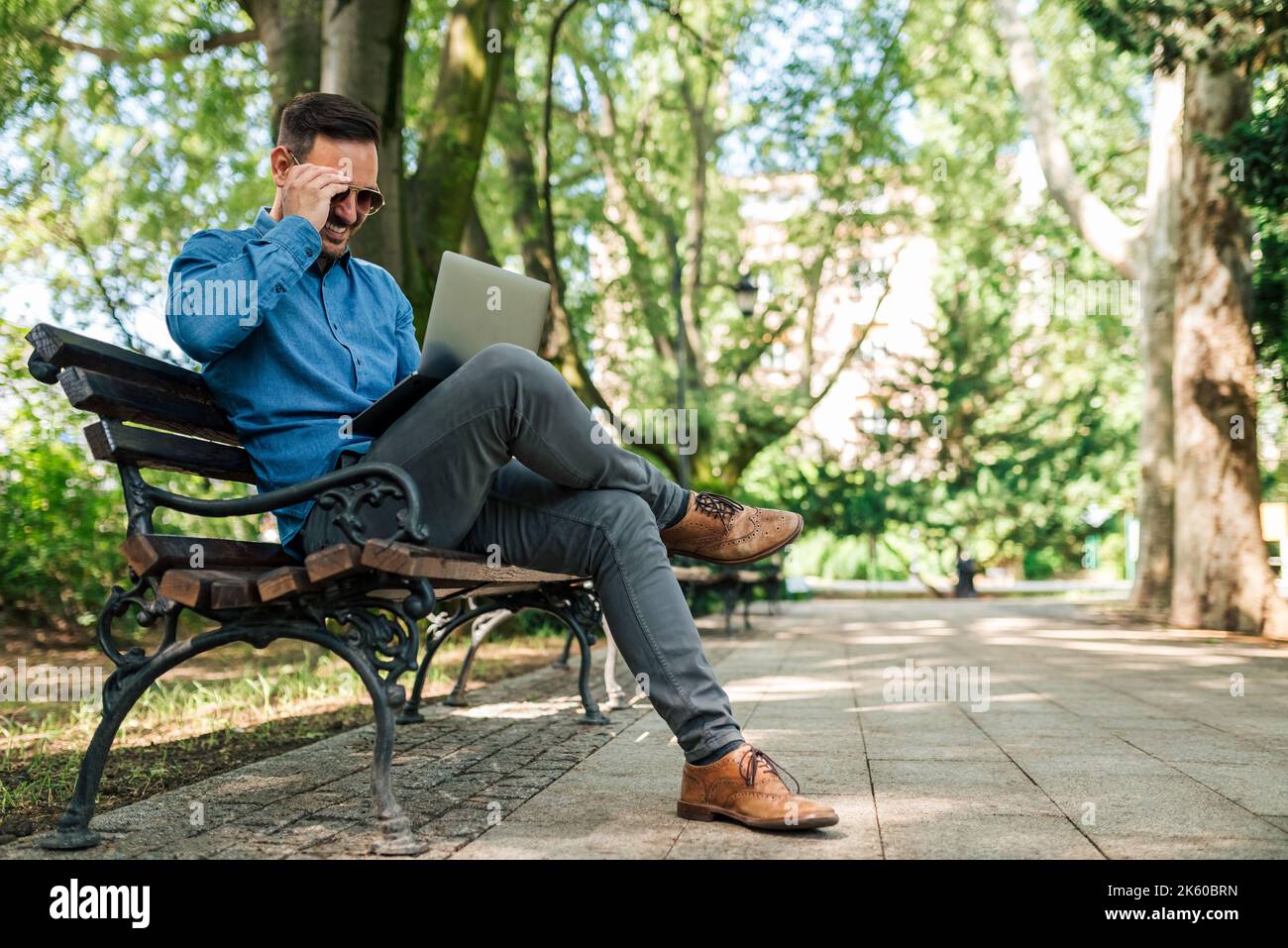 Calm bearded programmer, checking his code on his laptop, in the nature ...