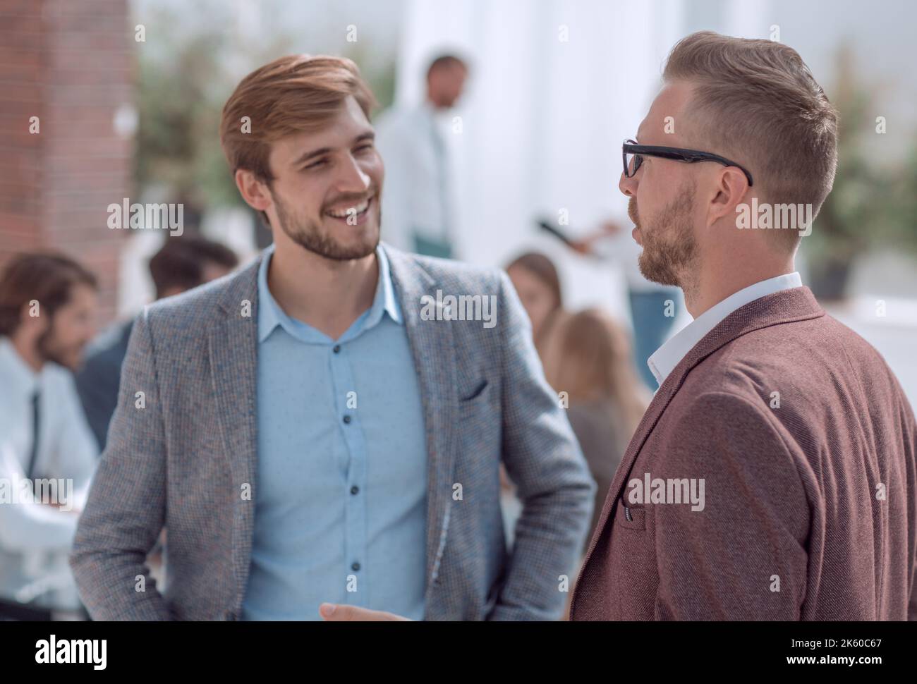 two business men talking standing in the office Stock Photo - Alamy