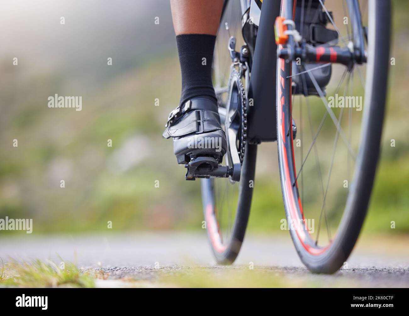 Closeup of one woman cycling outside. Sporty fit female athlete with ...