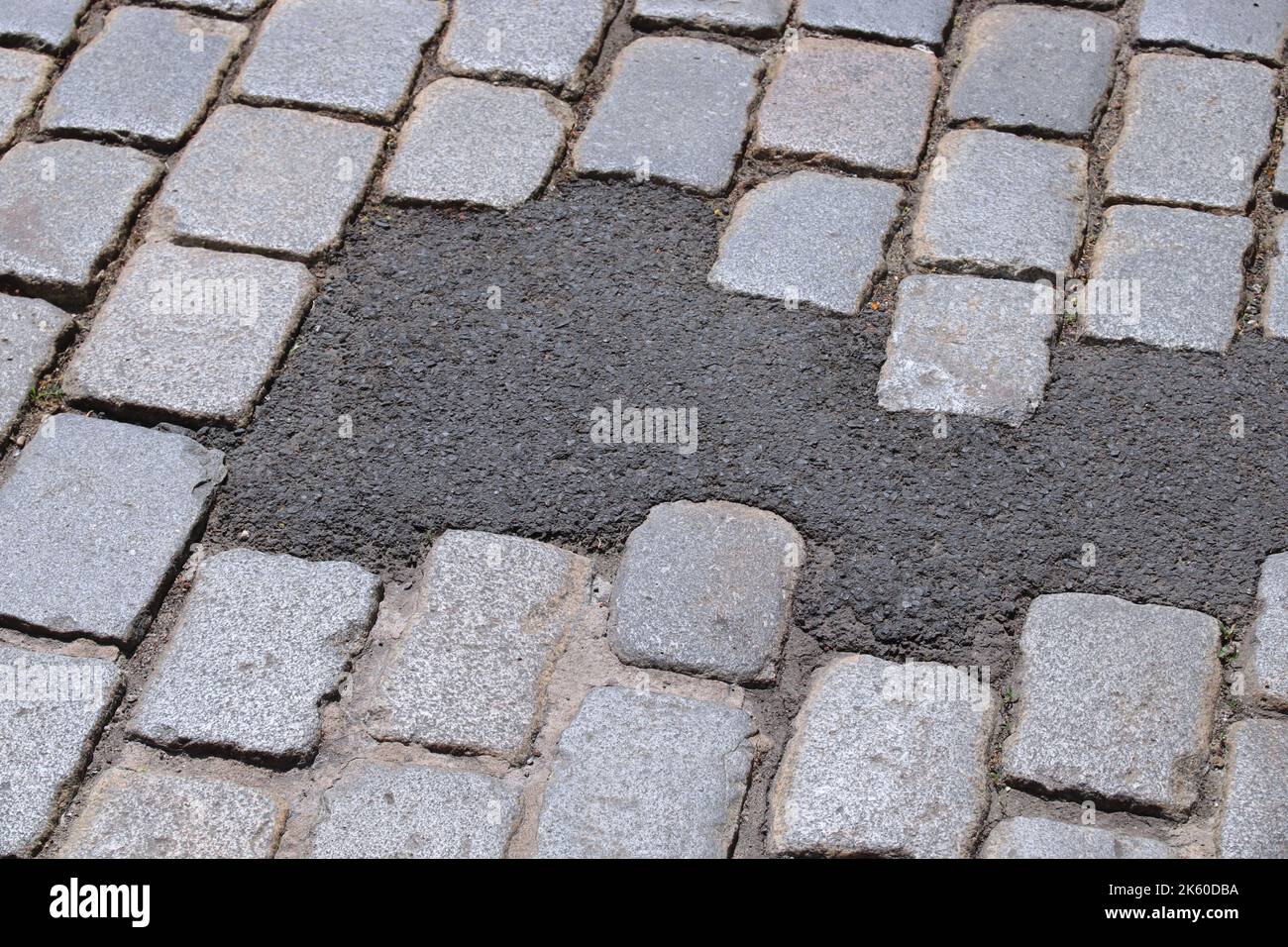 City street pothole temporary fix. Old stone pavement damage fixed with ...