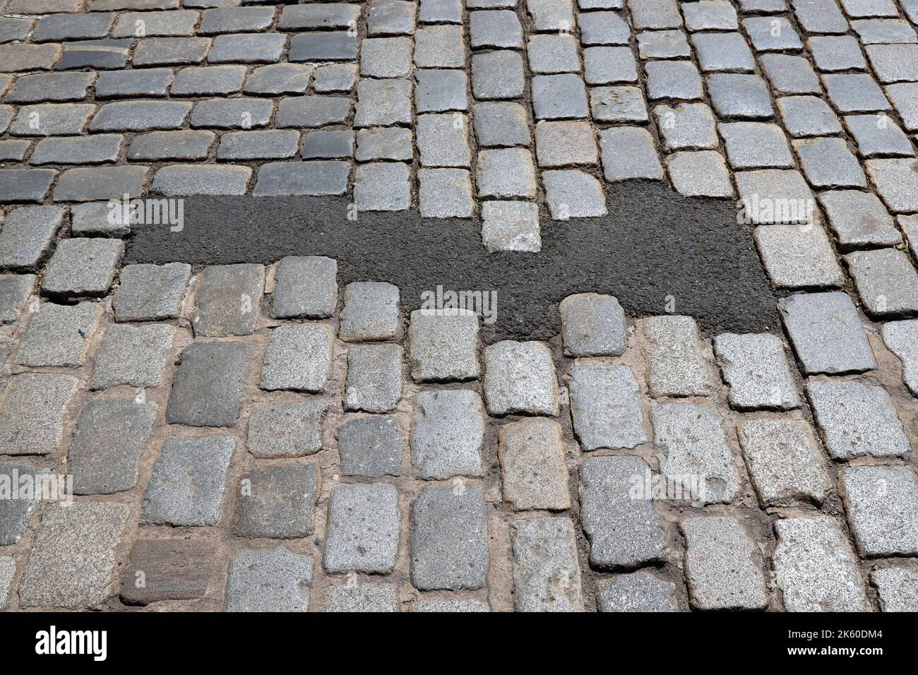Damaged stone pavement in Nuremberg, Germany. Cobblestone fixed with ...