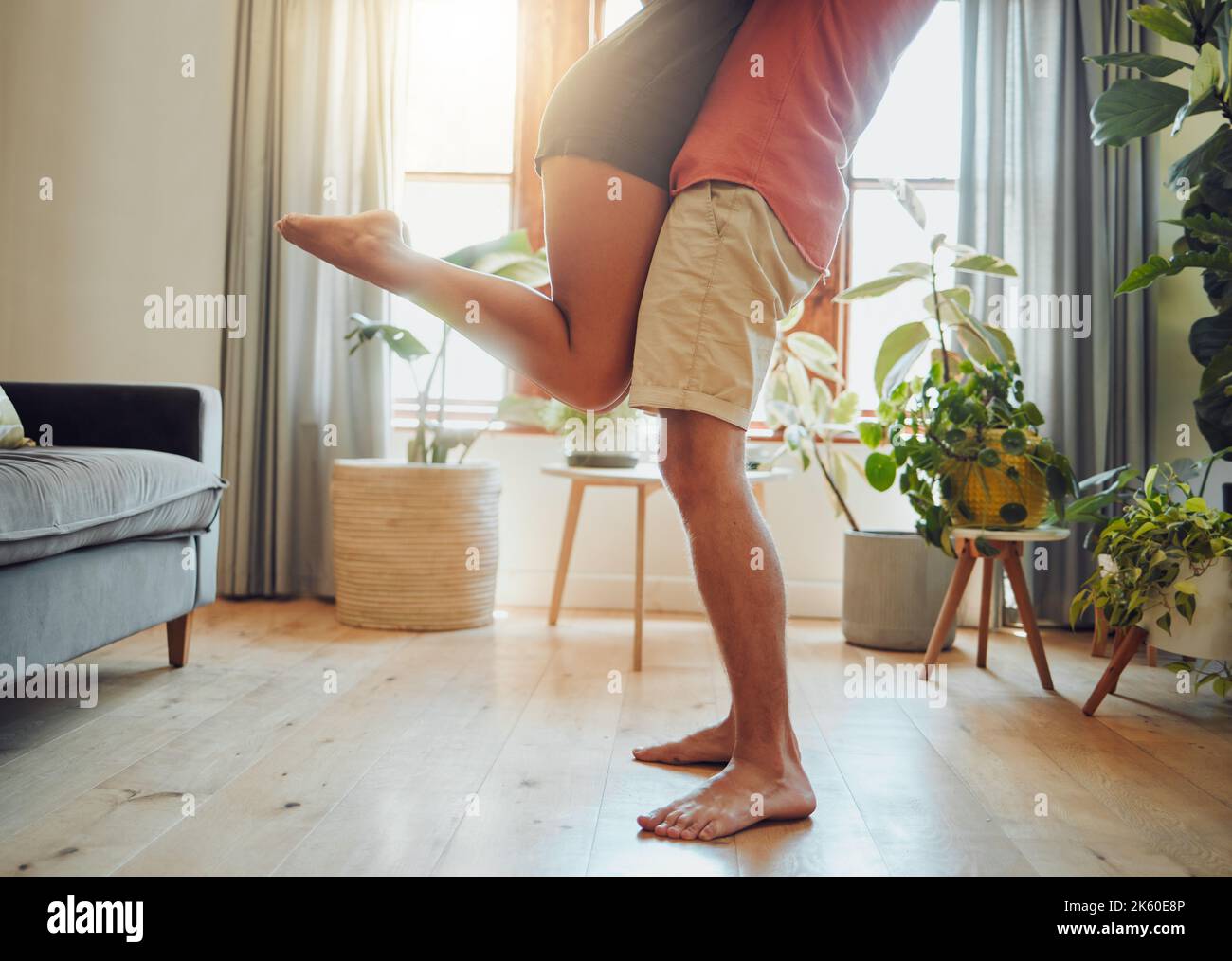 Close up of young boyfriend in shorts lifting girlfriend up in modern ...