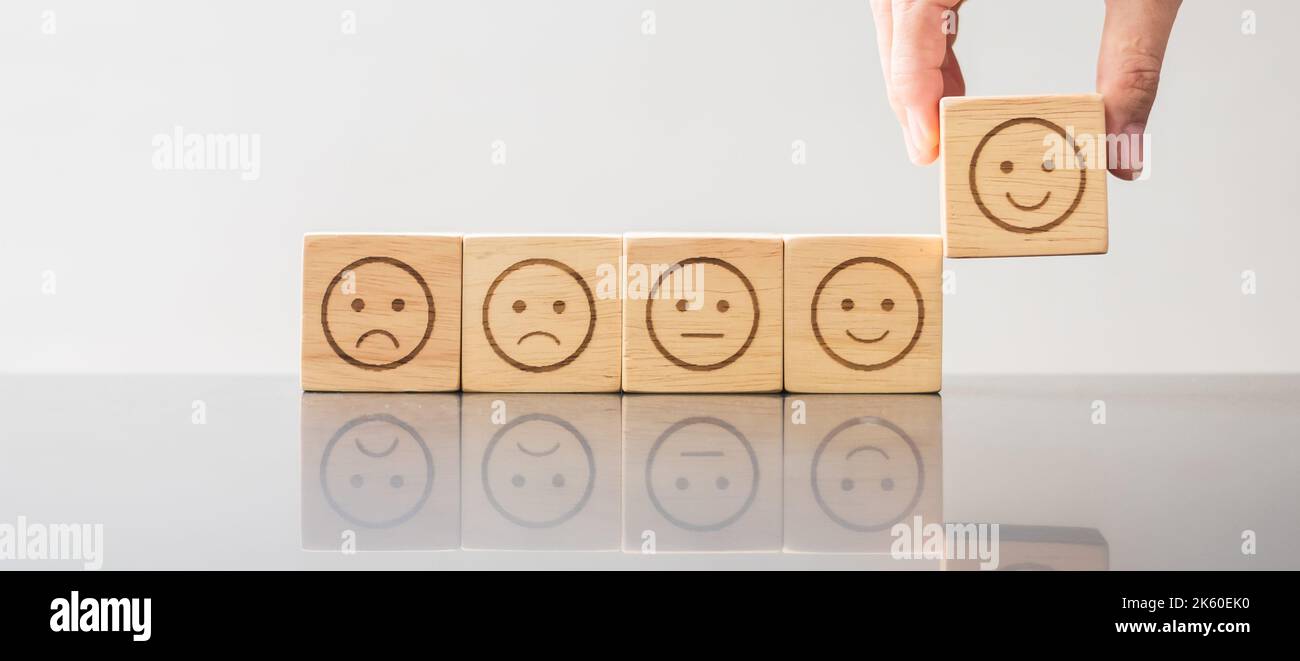 Man hand holding emotion face block. Customer choose Emoticon for user ...