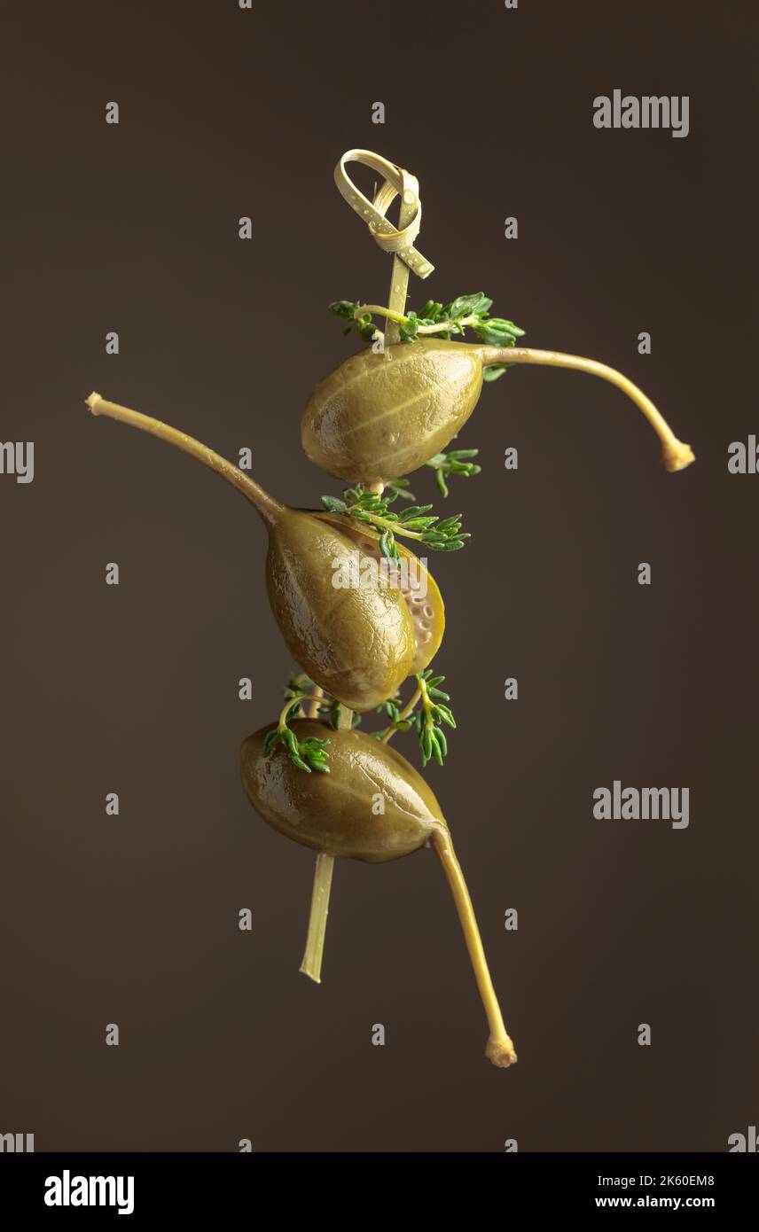 Large pickled canned capers with thyme on a bamboo stick Stock Photo ...