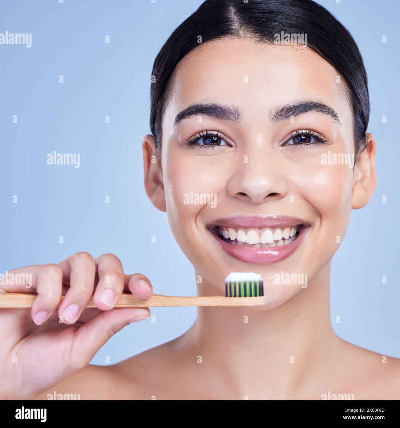 Studio portrait of a smiling mixed race young woman with glowing skin ...