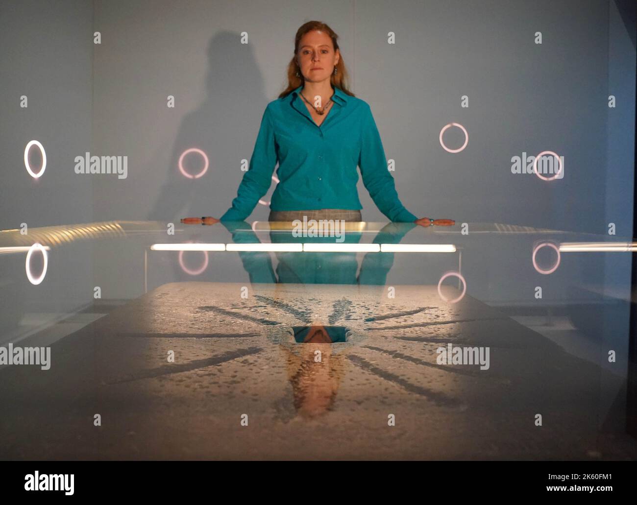 A member of staff observes the Shabaka Stone on display during the ...