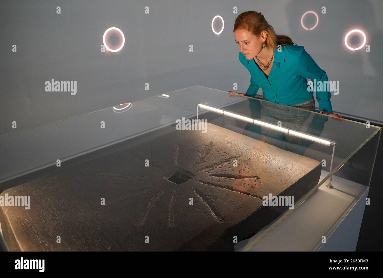 A member of staff observes the Shabaka Stone on display during the ...