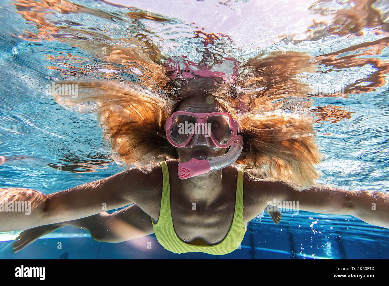 Close-up of a woman in snorkeling mask dive underwater in swimming pool ...
