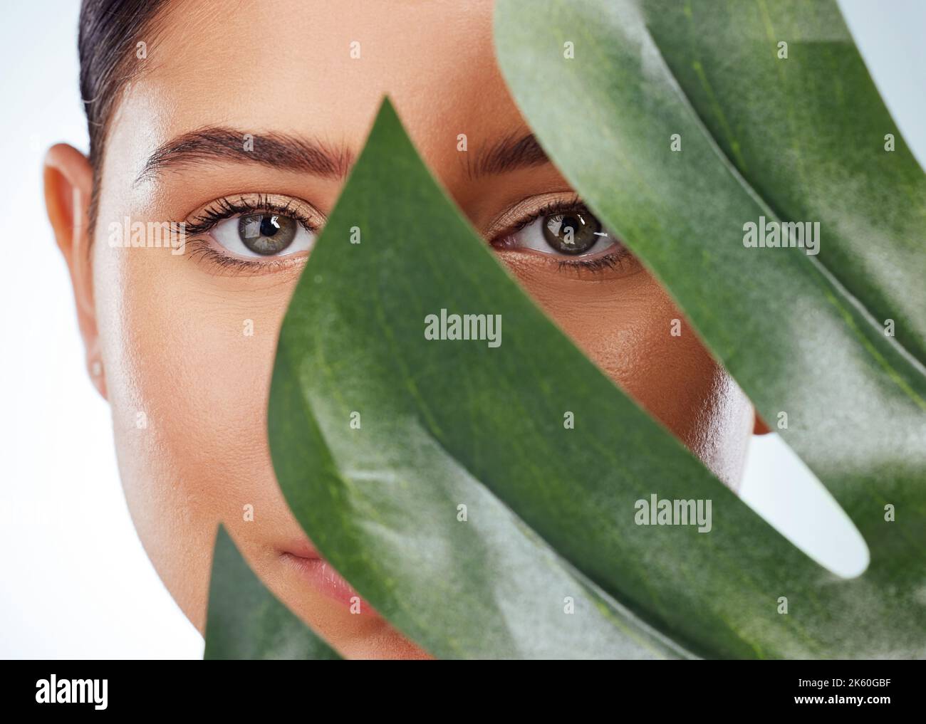 Closeup portrait of unknown woman covering her face with a green ...