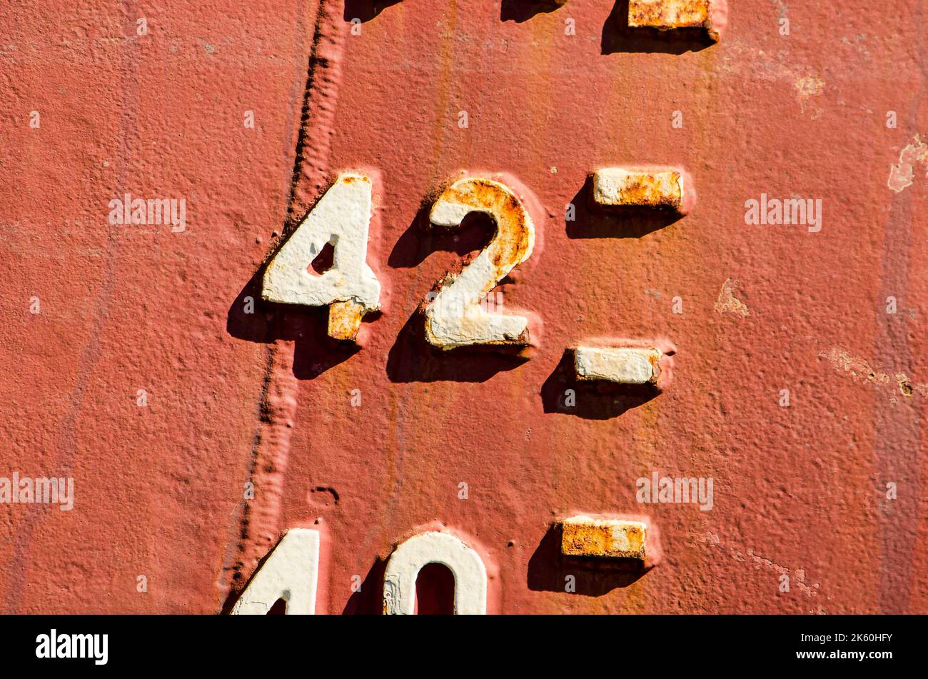 Close-up of the draught marks on a weathered ship's hull, focussing on ...