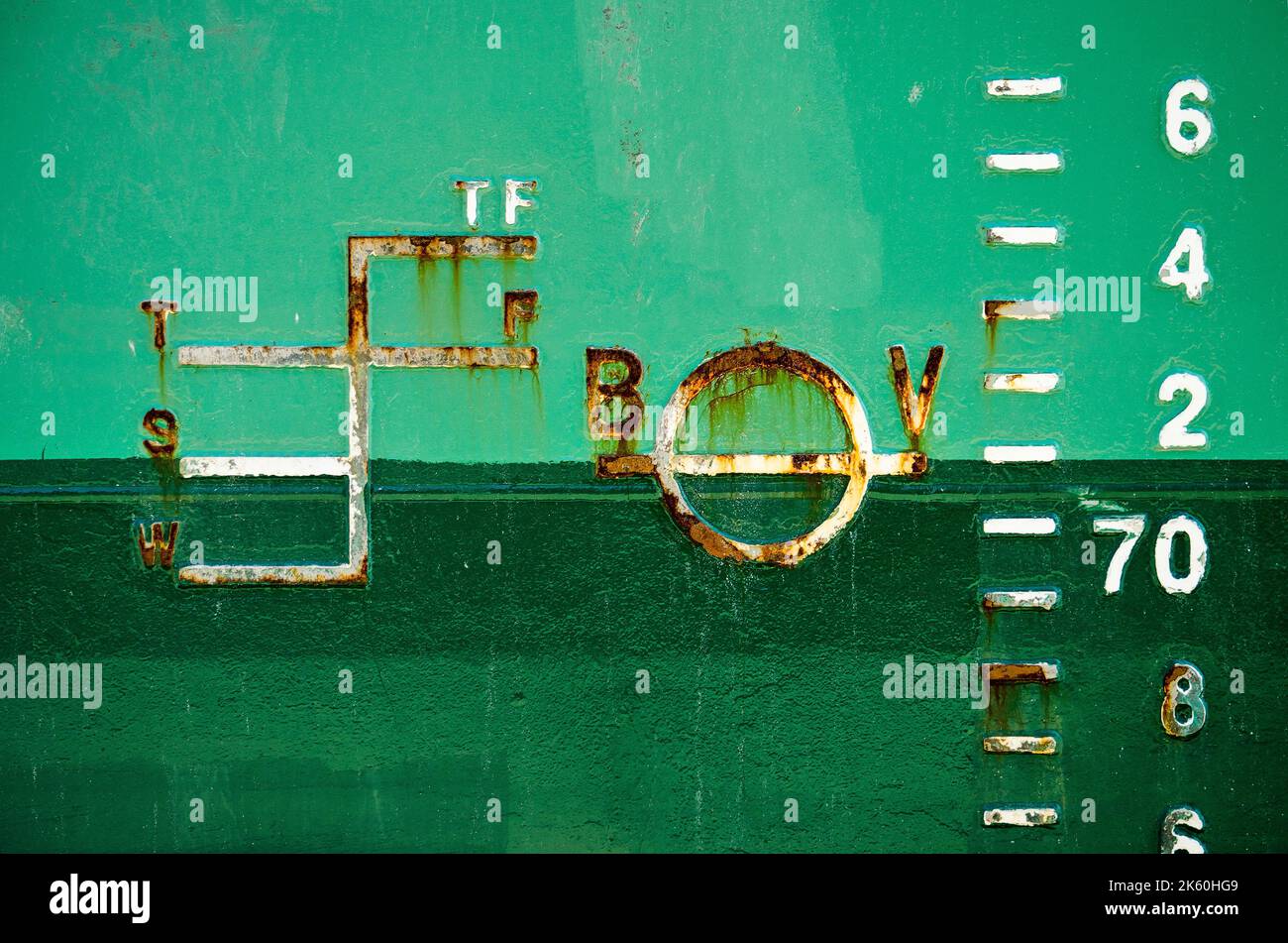 Draught marks on the steel hull of a ship, painted light and dark green ...