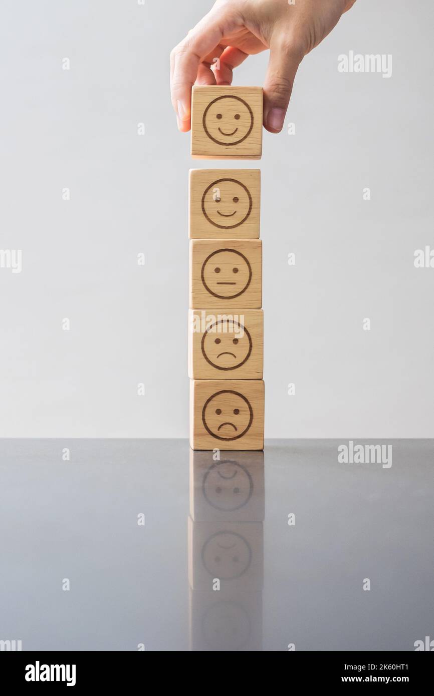 Man hand holding emotion face block. Customer choose Emoticon for user ...