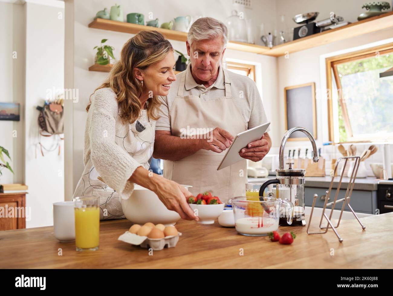 Recipe, cooking and senior couple on a tablet in the kitchen with ...
