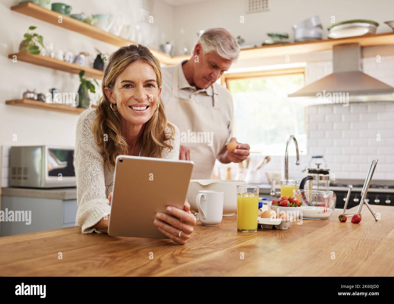 Tablet, baking and retirement with a senior couple cooking in the ...