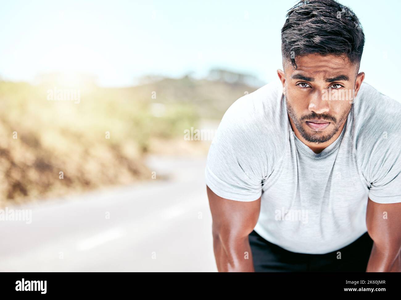 Fit young mixed race man resting while exercising outdoors. Handsome ...