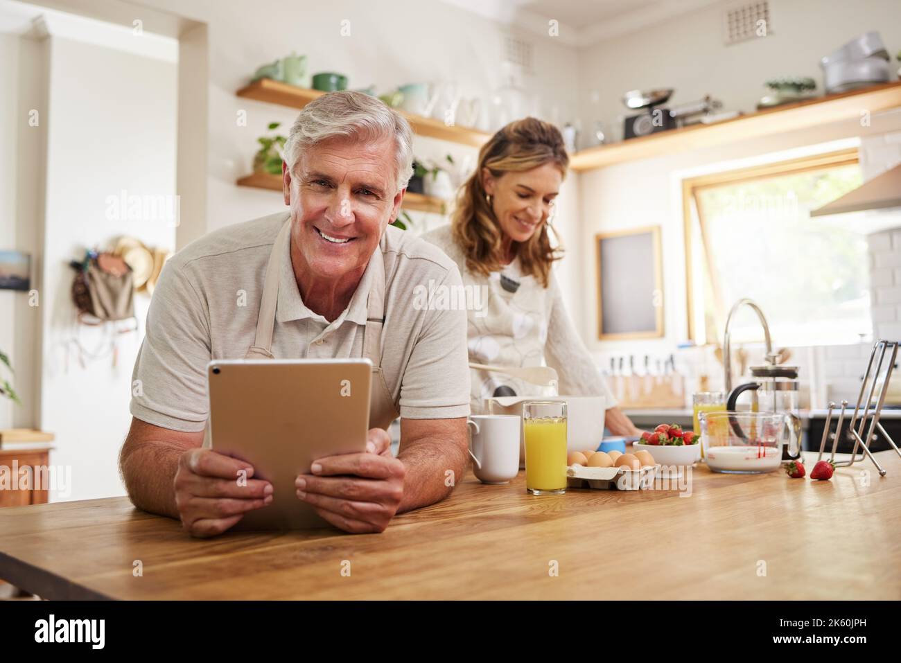 Portrait, senior couple and cooking with tablet together in a modern ...