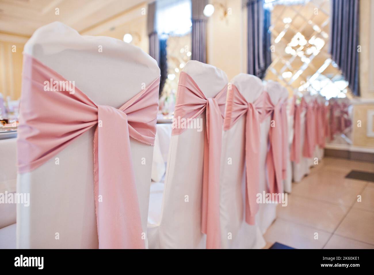 Chairs with pink ribbons at wedding table in restaurant Stock Photo - Alamy