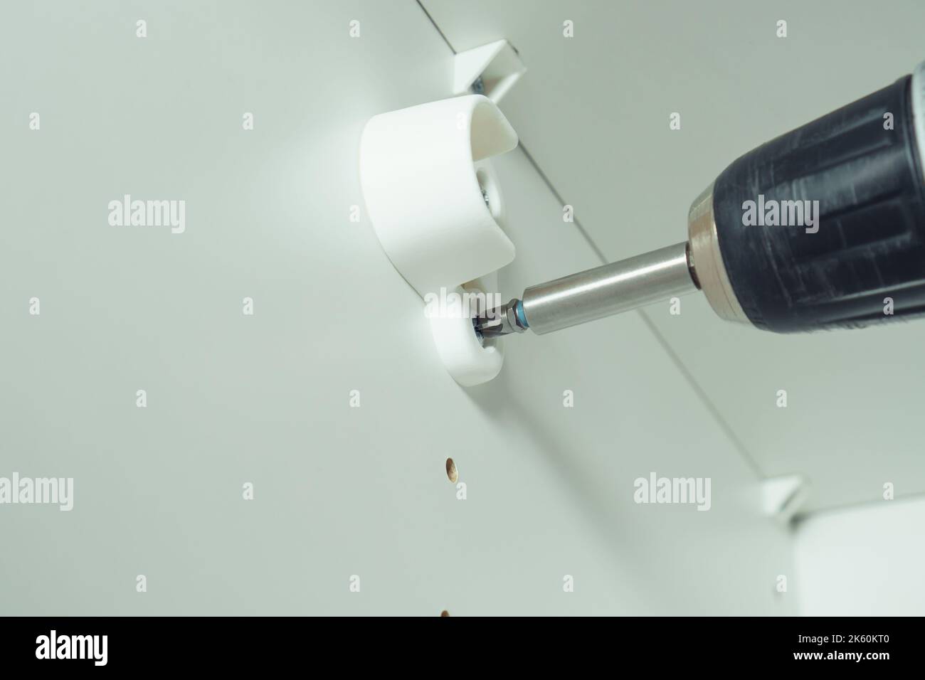 Closeup of screw in to insert plastic support into one of series of ...