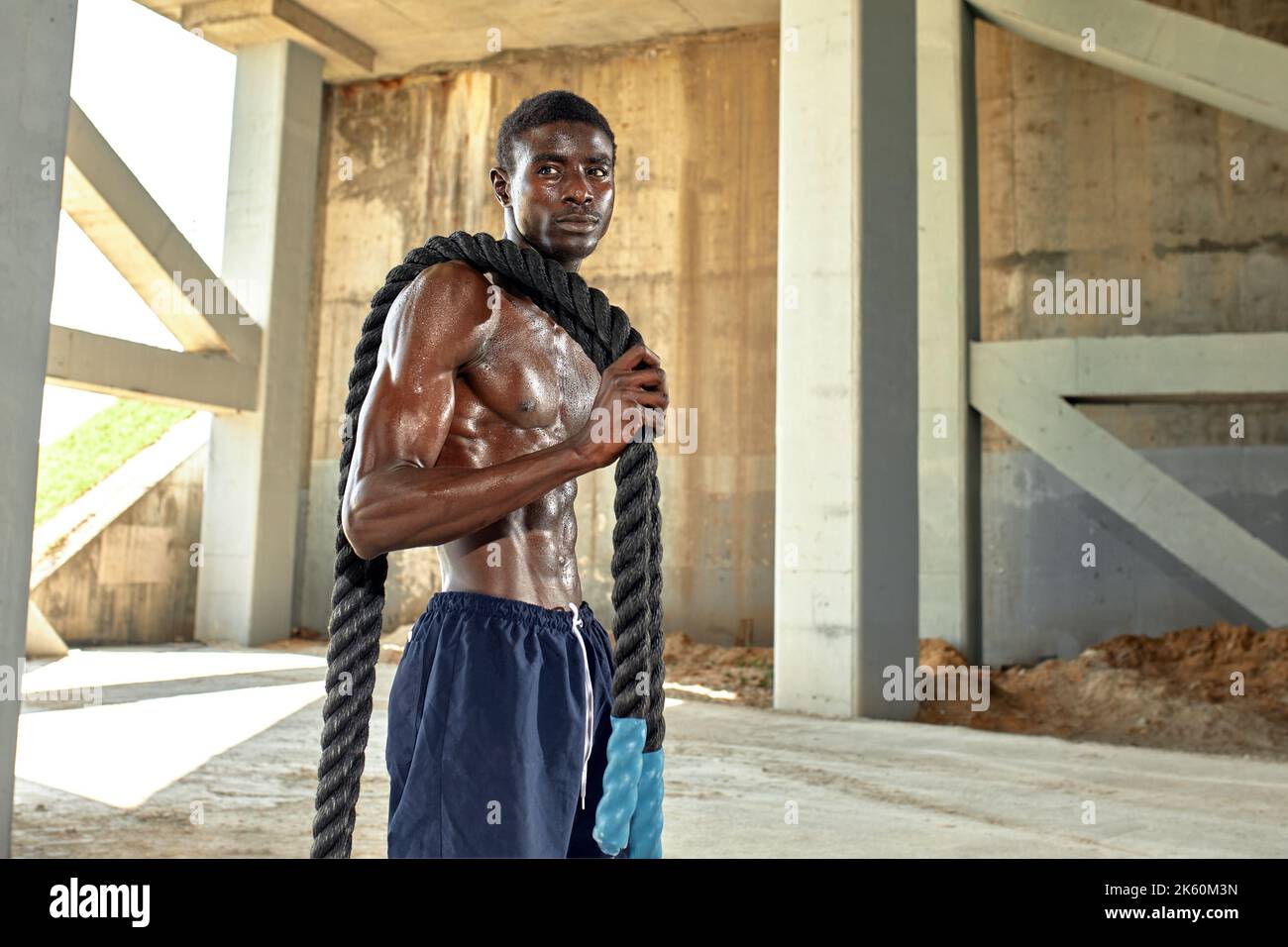 Rope workout. Sport man doing battle ropes exercise outdoor. Black male ...