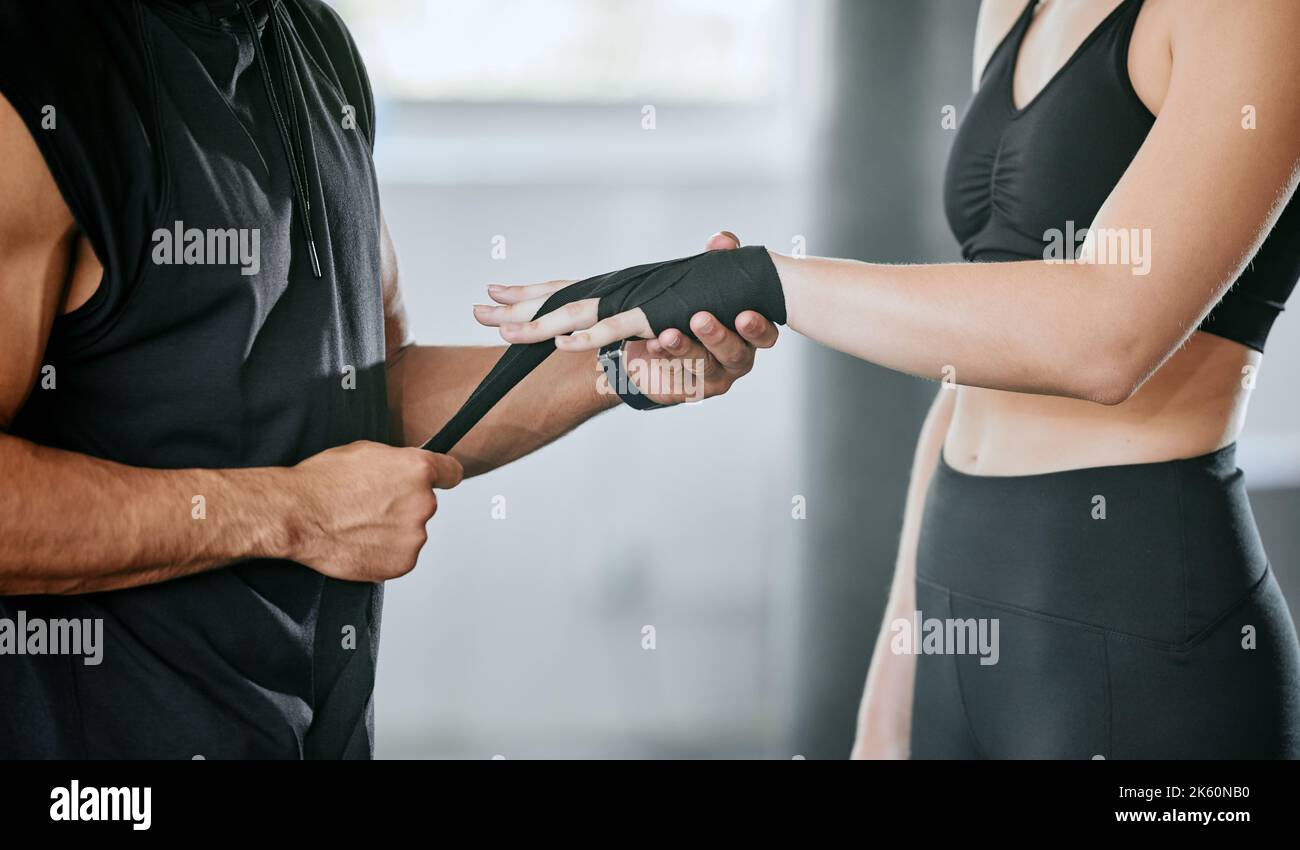 Unknown mixed race trainer wrapping caucasian boxers hands in gym ...