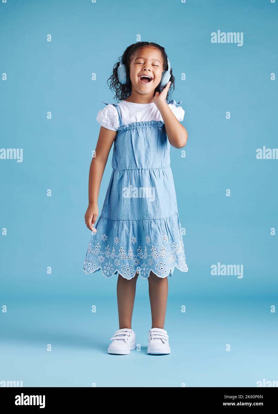 Full length of an adorable little hispanic girl singing with her eyes ...