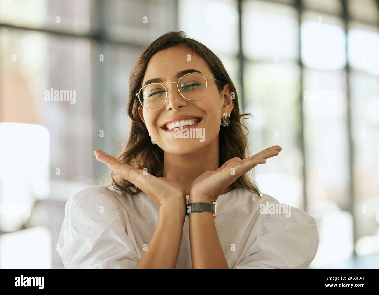 Cheerful business woman with glasses posing with her hands under her ...