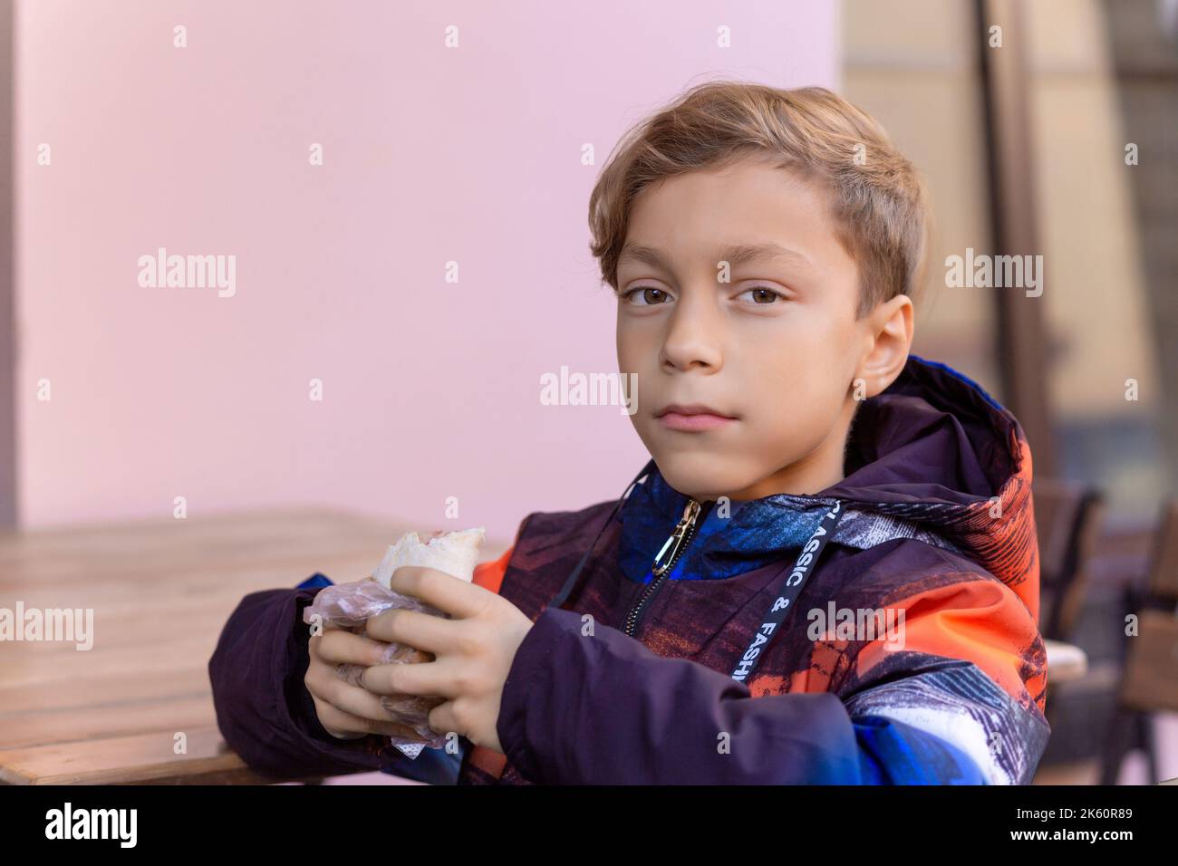Cute trendy teen boy eating kebab in street cafe. Street food concept ...