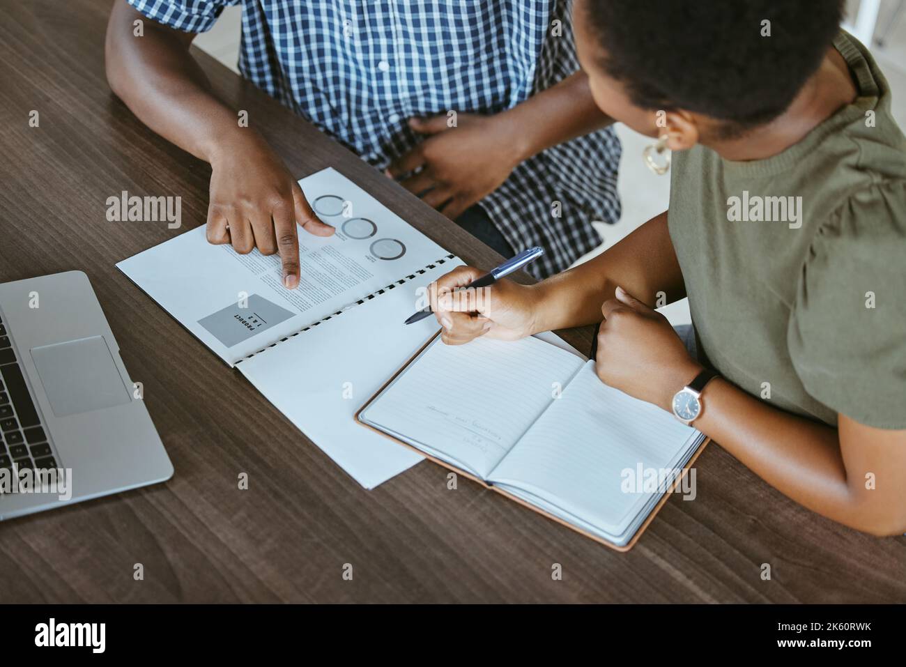 Two businesspeople having a meeting and looking at a report together at ...