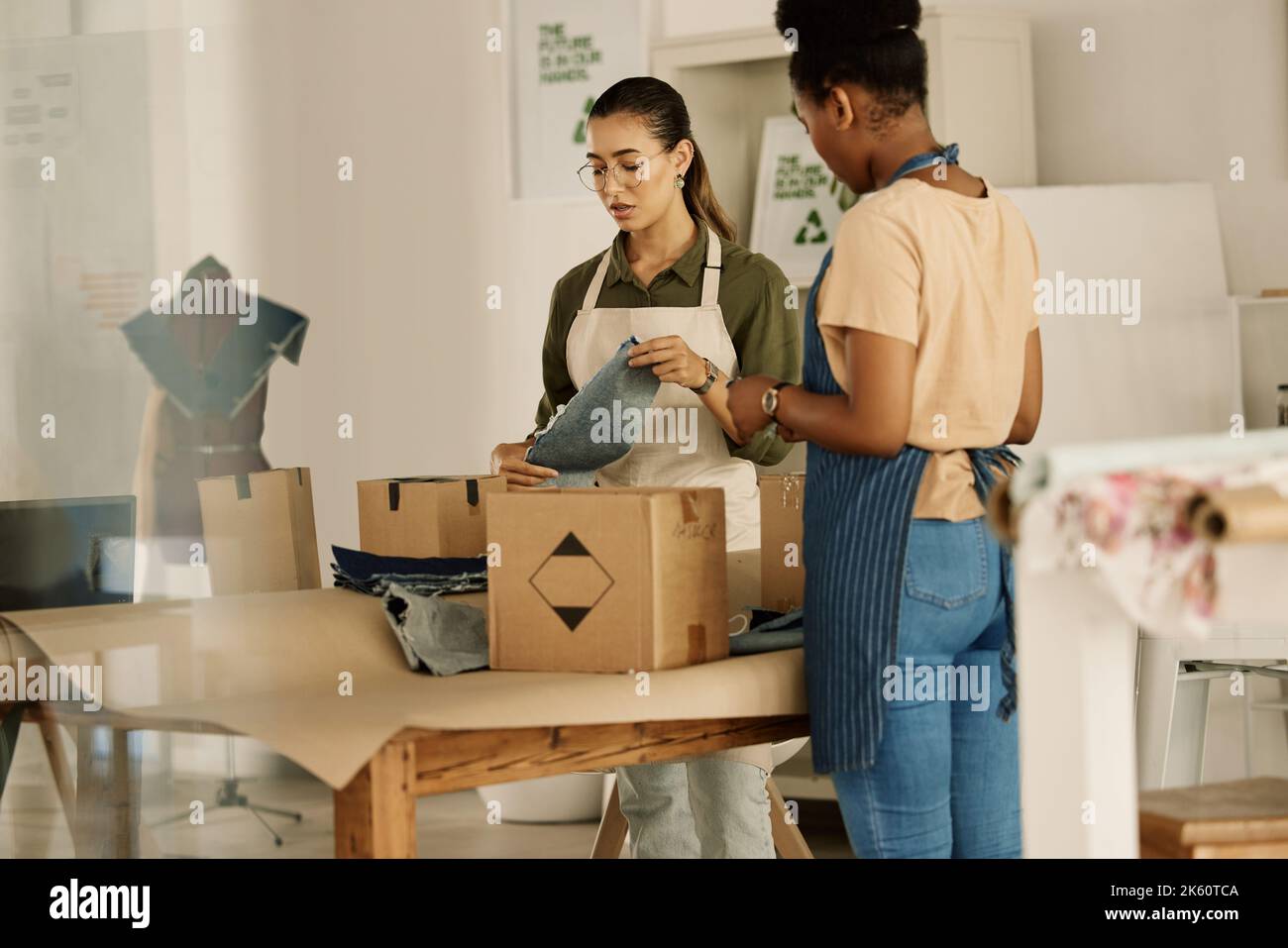 Two colleagues unpacking boxes. Fashion designers packing stock order ...