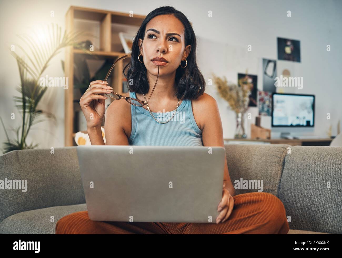 Beautiful mixed race woman thinking while using laptop for blogging in ...