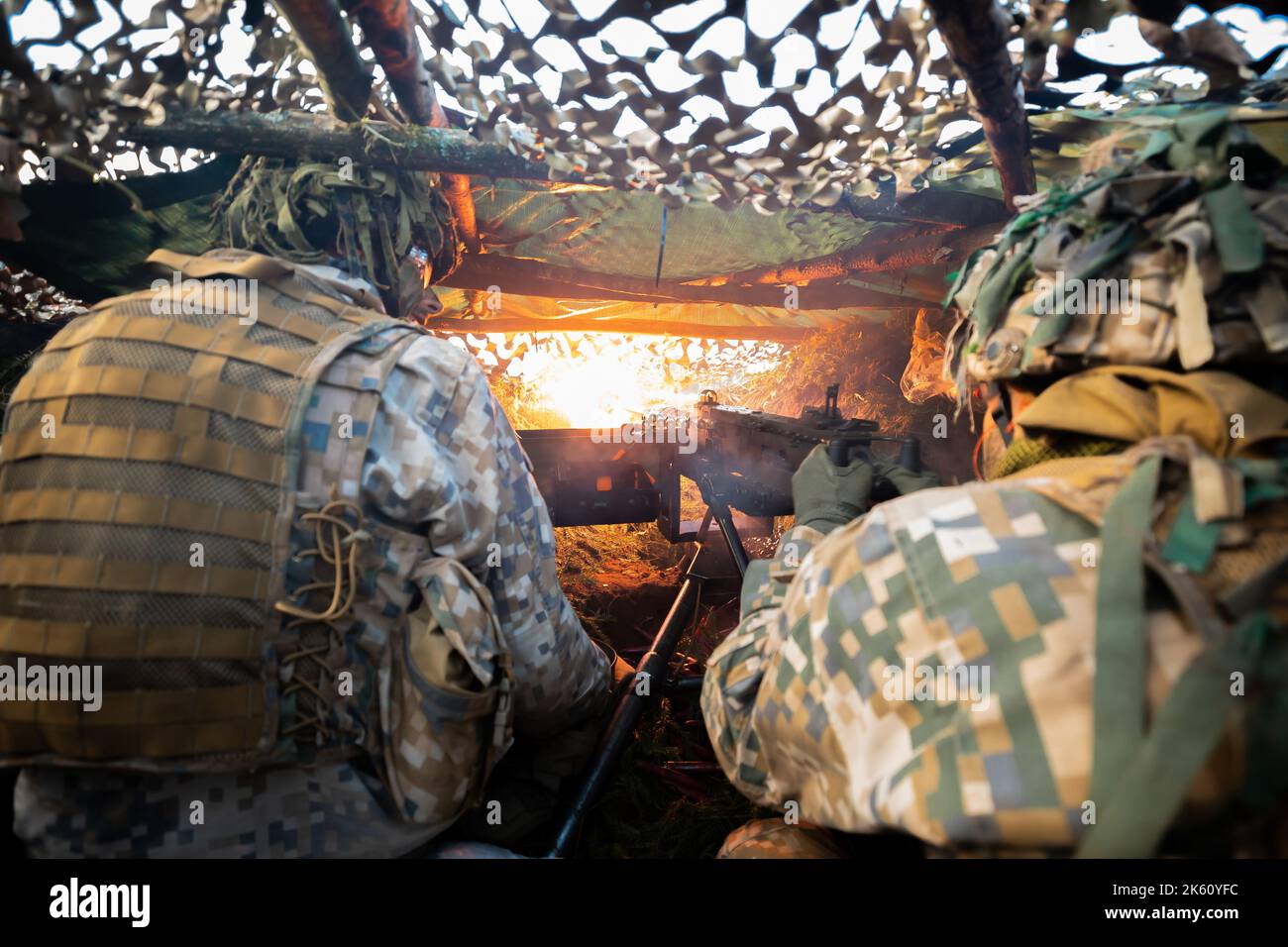 Close-up soldiers firing a 50 Cal Machine gun with spent brass around ...