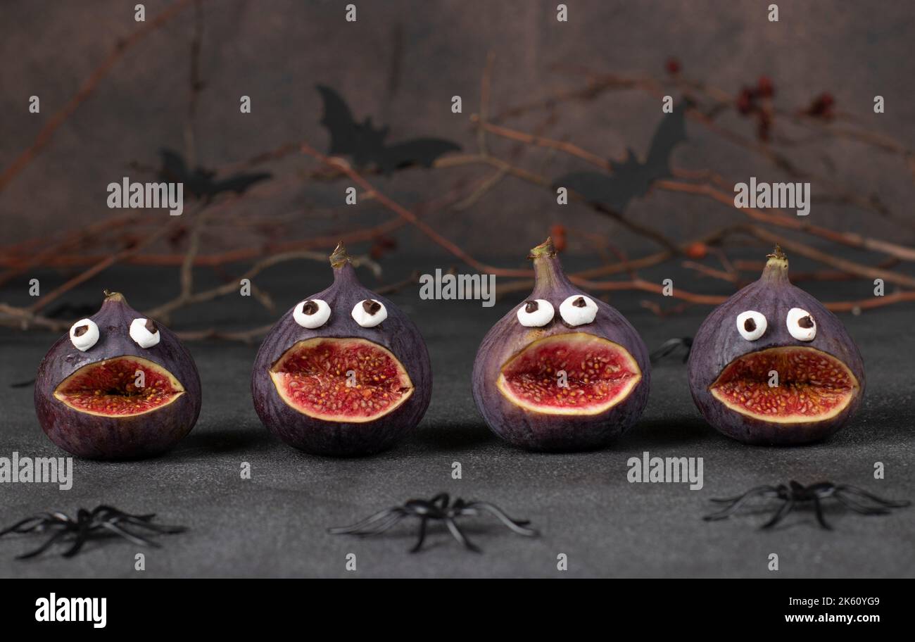 Spooky fig monsters for Halloween party on brown background decorated ...