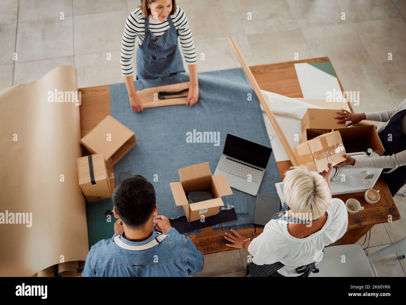 Four diverse clothing designers packing their products working together ...