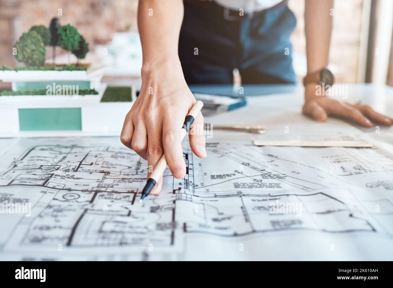Closeup shot hand of a woman architect holding a pen and looking over ...