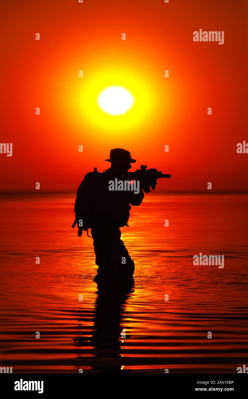 Army soldier with rifle orange sunset silhouette crossing river Stock ...