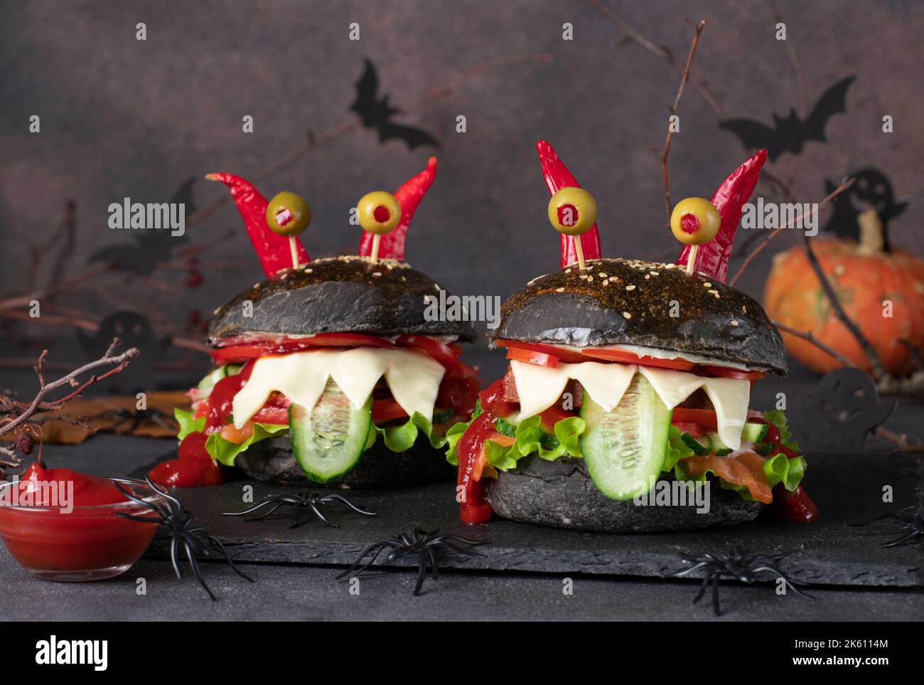 Two funny monster black burgers with fish, toast cheese, cucumber ...